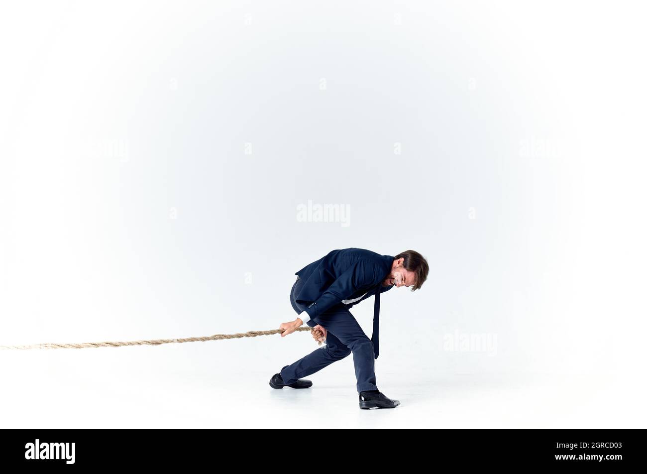 business man in suit pulling rope Studio team work Stock Photo - Alamy