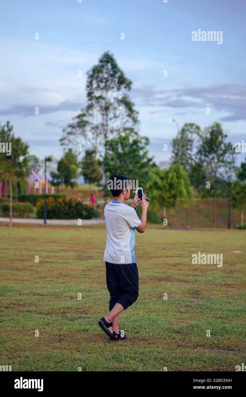 Full Length Rear View Of Man Photographing On Field Stock Photo - Alamy