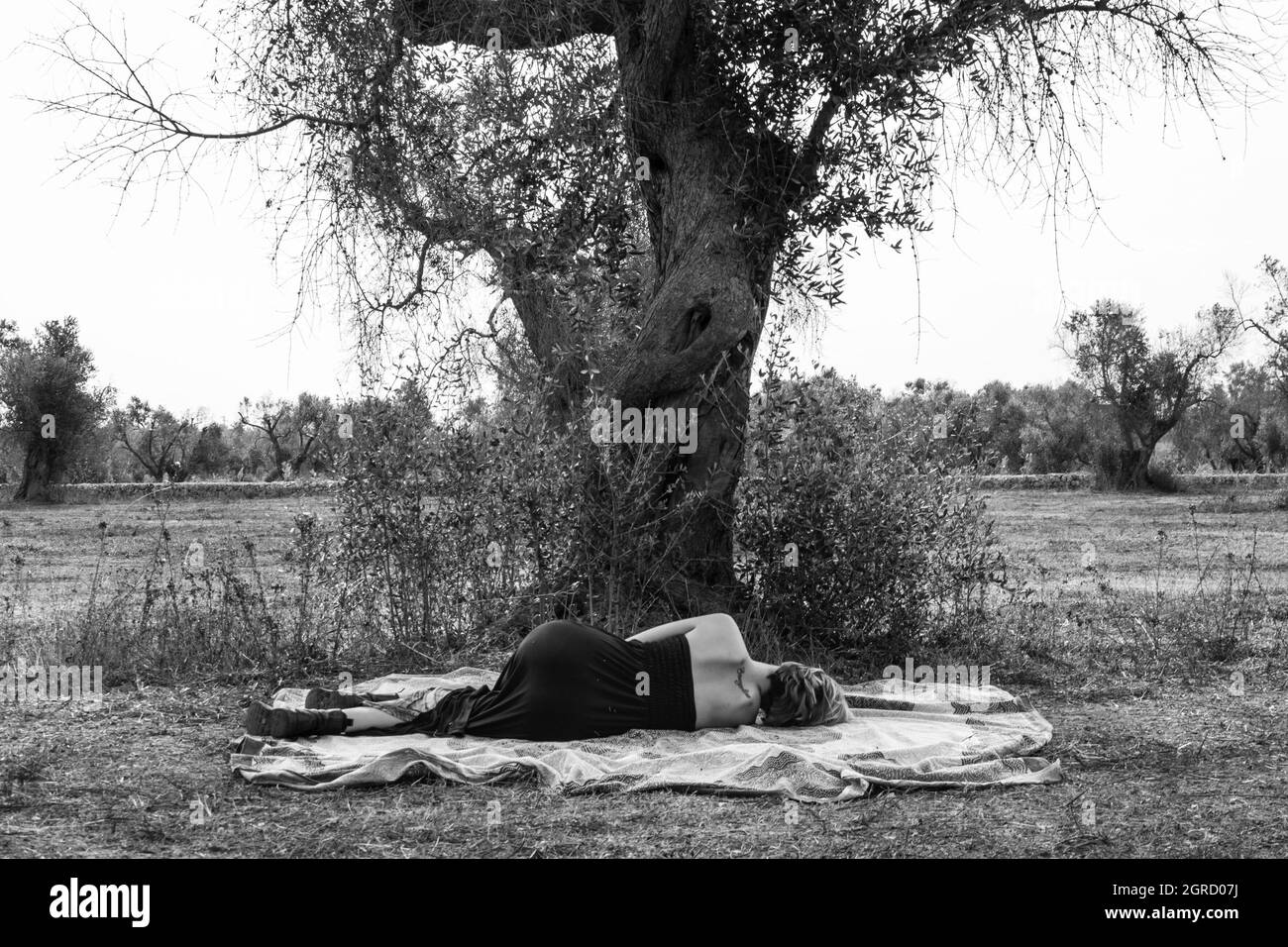 Young woman lying under tree hi-res stock photography and images - Alamy