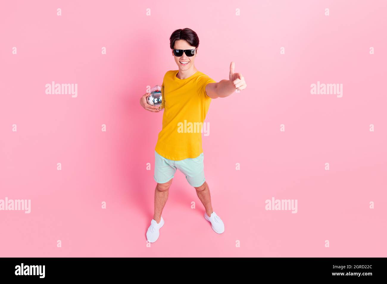 Photo of pretty charming man wear yellow t-shirt dark eyewear pointing ...