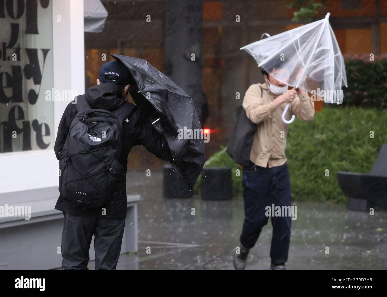 Tokyo, Japan. 1st Oct, 2021. Pedestrians walk against strong wind and ...