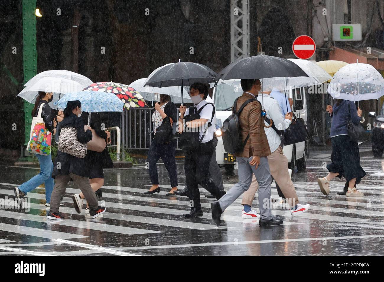 Tokyo, Japan. 1st Oct, 2021. Pedestrians holding umbrellas walk under a ...