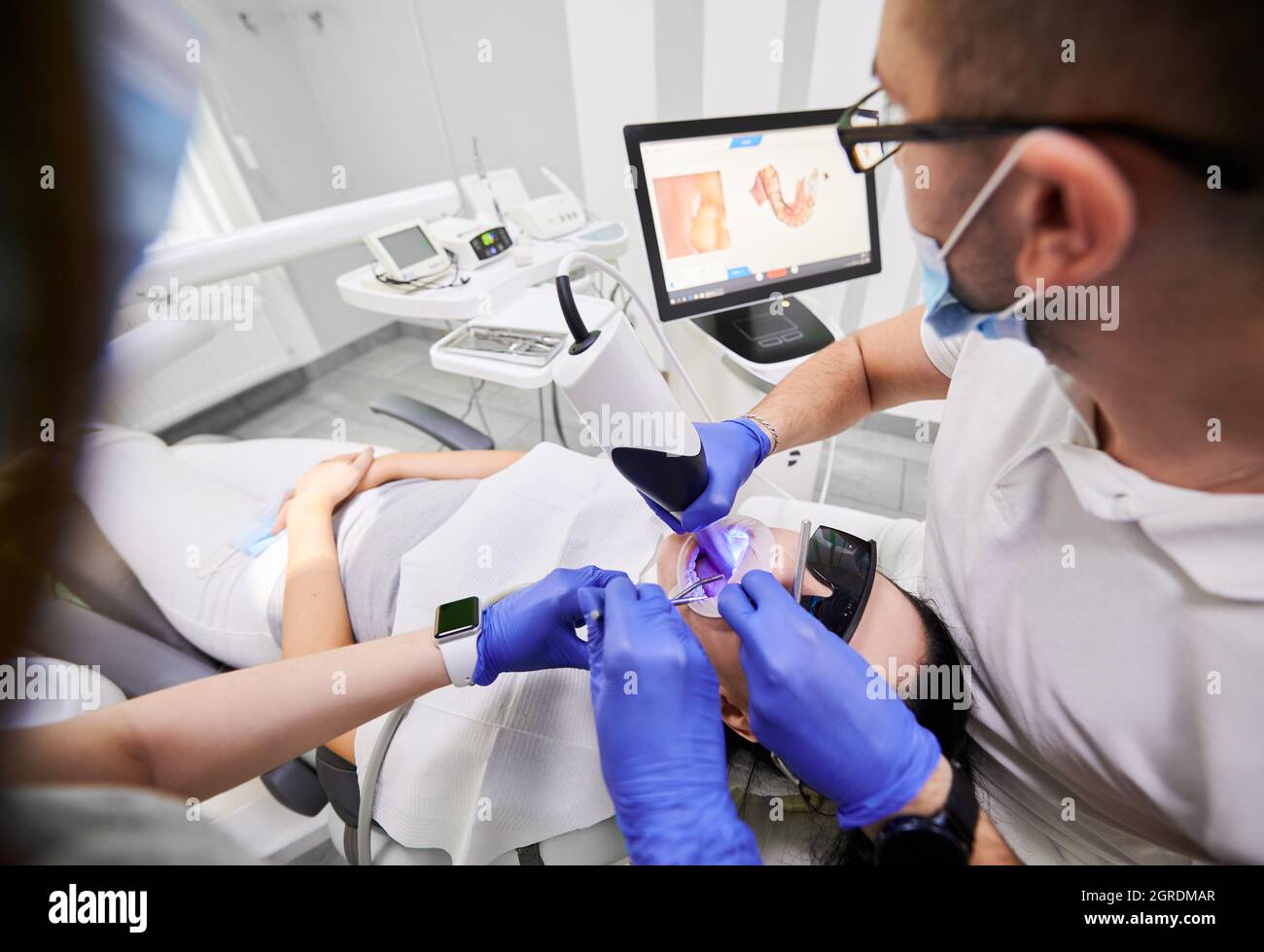 Dentist and his assistant scanning patient's teeth with modern scanning ...
