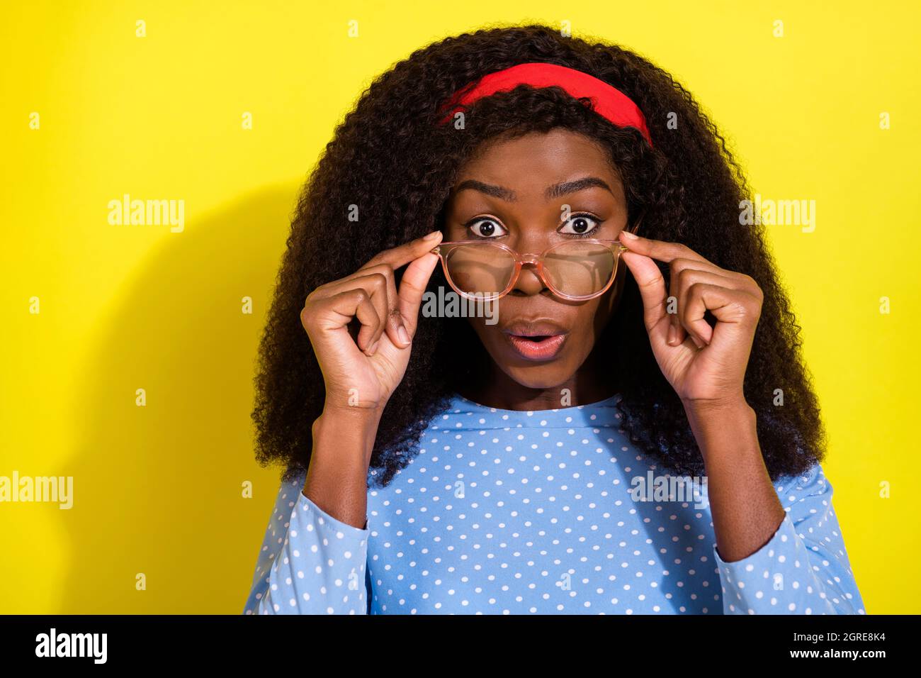 Photo of astonished curly hairdo young lady touch spectacles wear blue ...