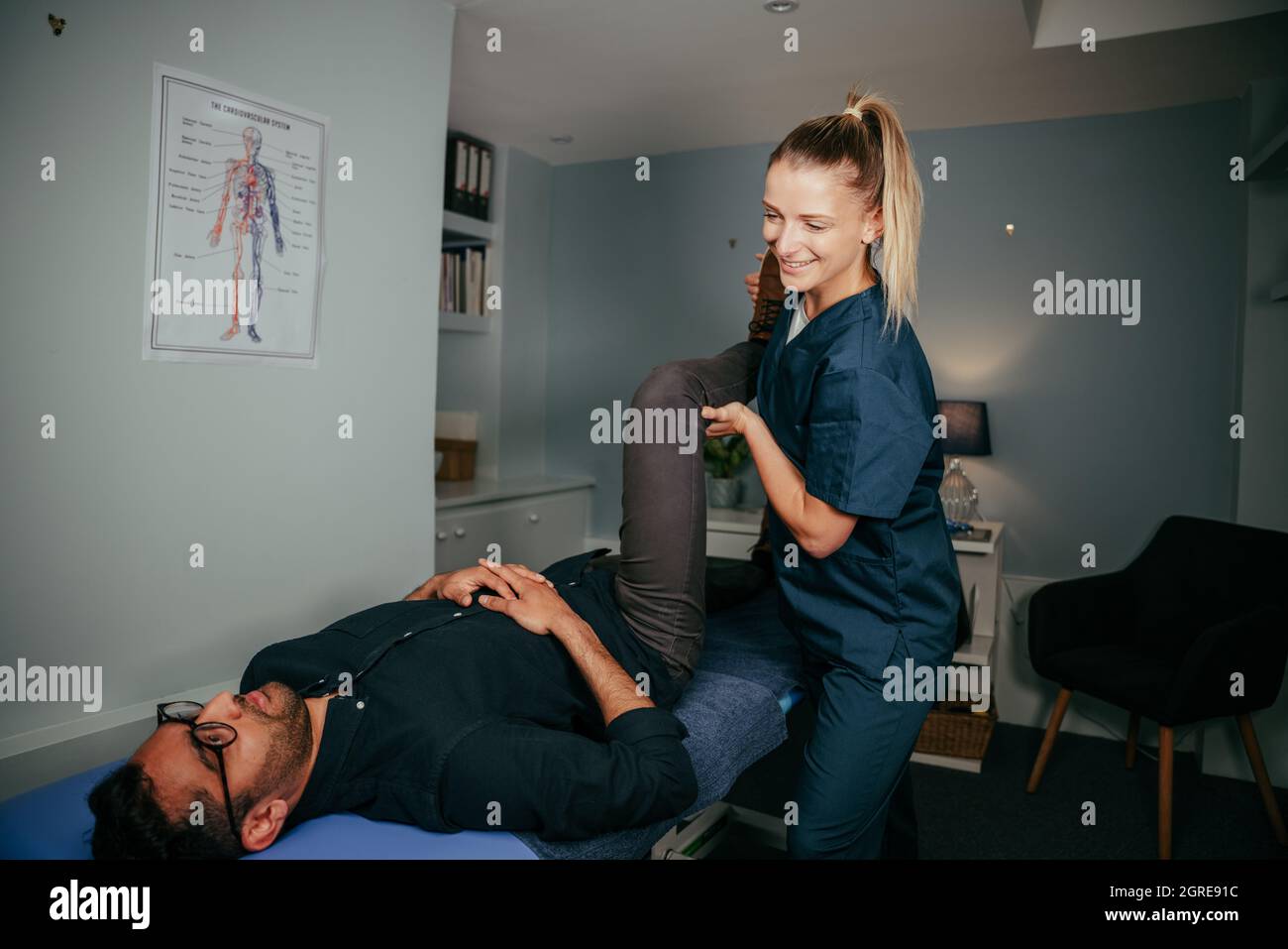Caucasian female physiotherapist assisting injured patient with ...