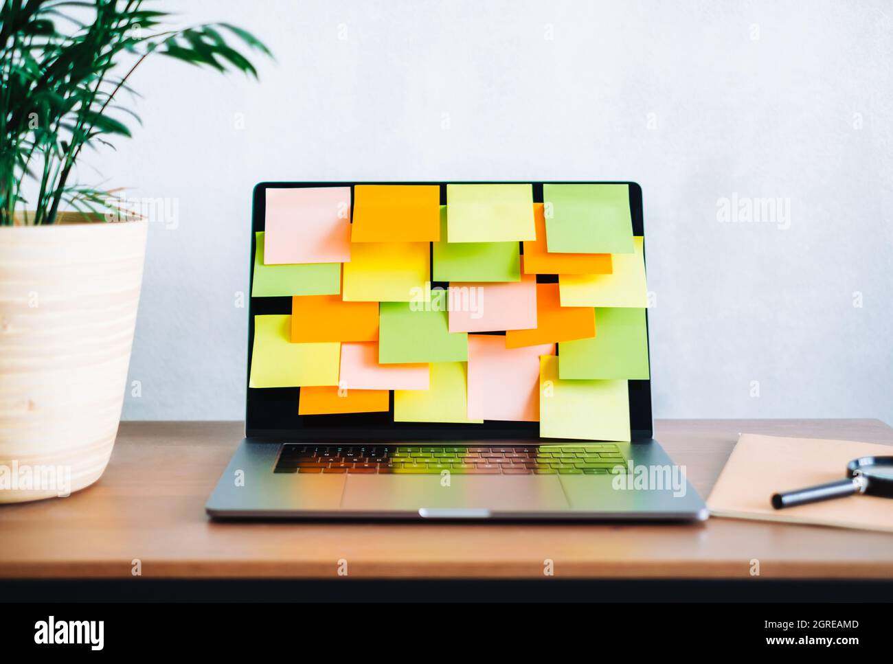 Workplace with laptop computer with many colorful empty sticky notes on ...
