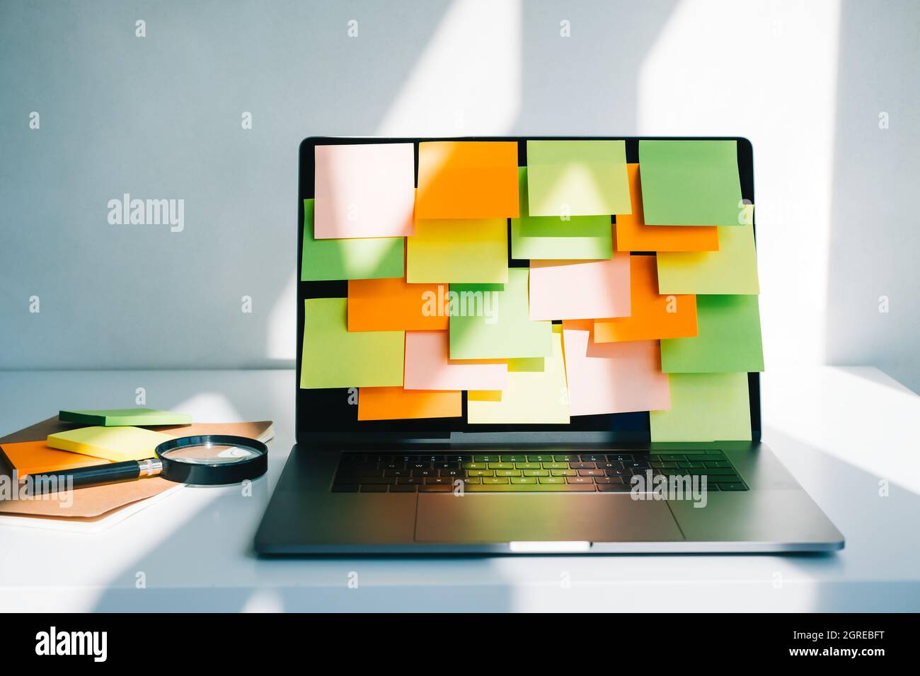 Workplace with laptop computer with many colorful empty sticky notes on ...