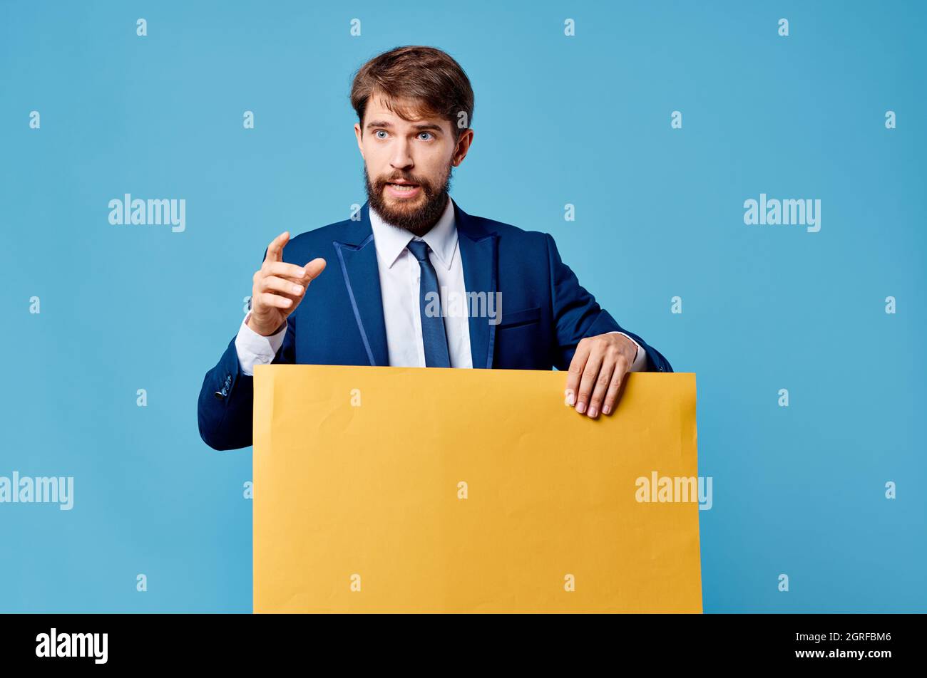 bearded man yellow mockup poster in hand blue background Stock Photo ...