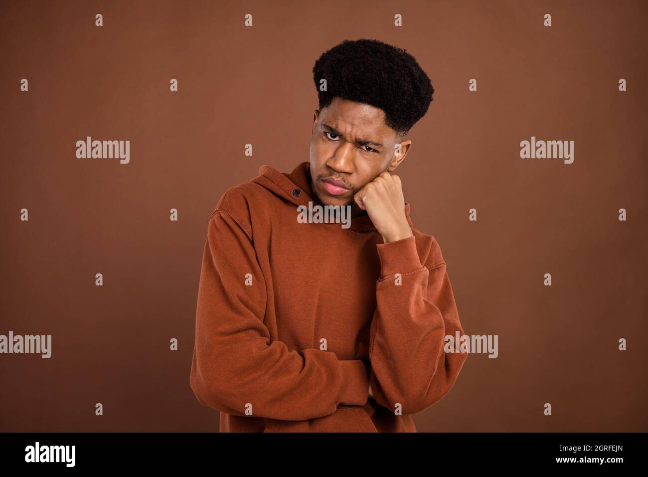 Photo of grumpy offended african guy look camera bad mood fist cheek ...