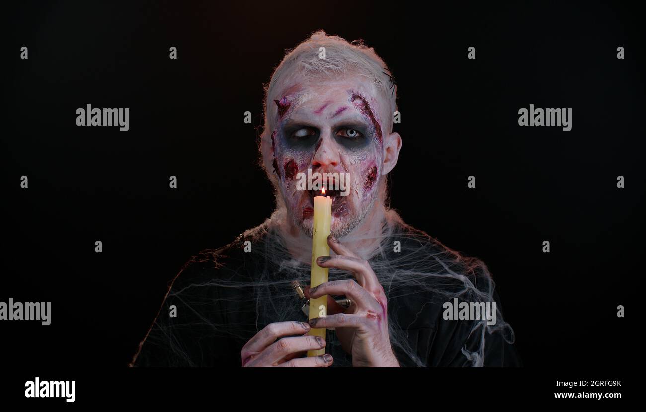 Sinister man with horrible scary Halloween zombie makeup making faces ...