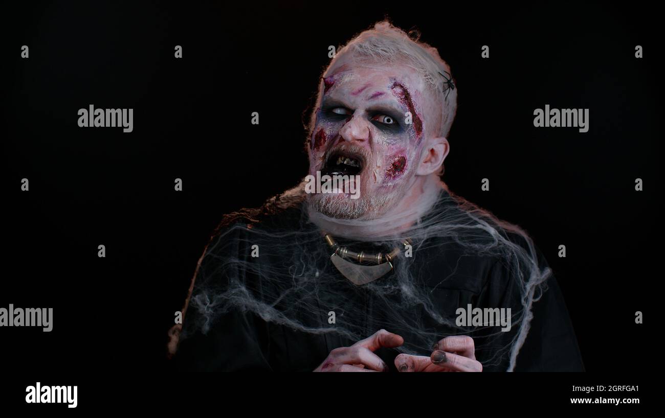Scary man with horrible scary Halloween zombie makeup in convulsions ...