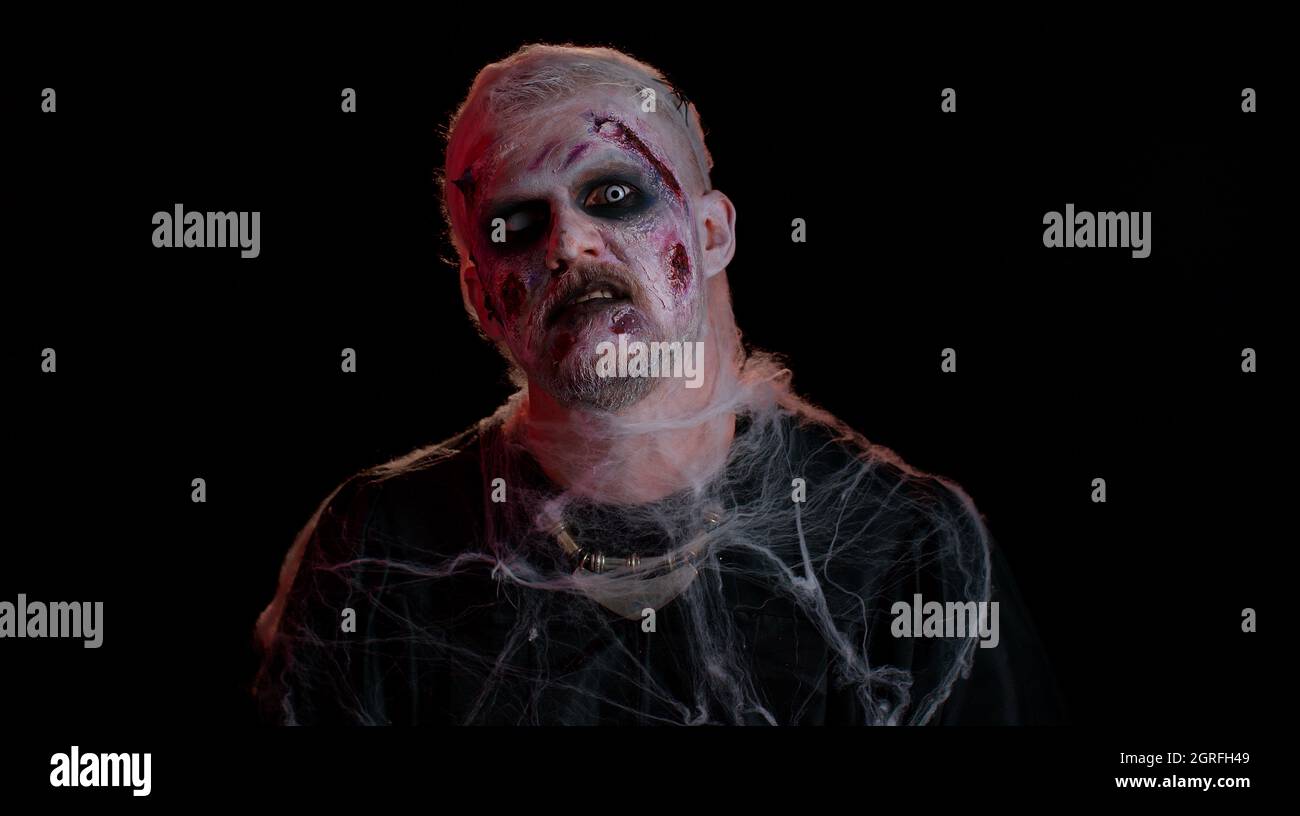 Sinister man scary Halloween zombie looking ominous at camera in police ...