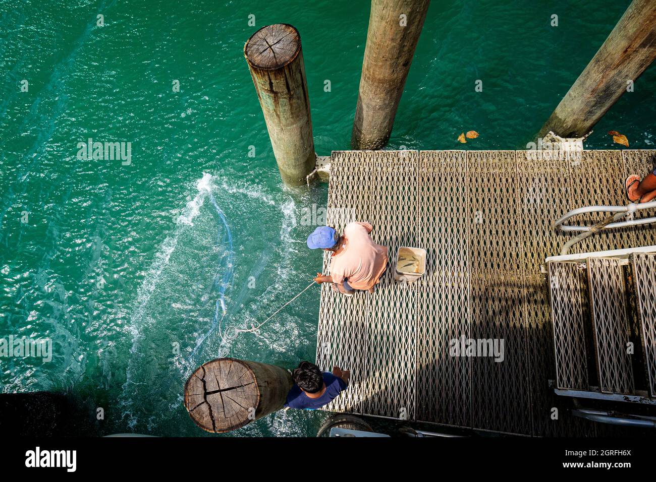 Fishermen catching bait with cast net at Seisia Jetty at Seisia Beach ...