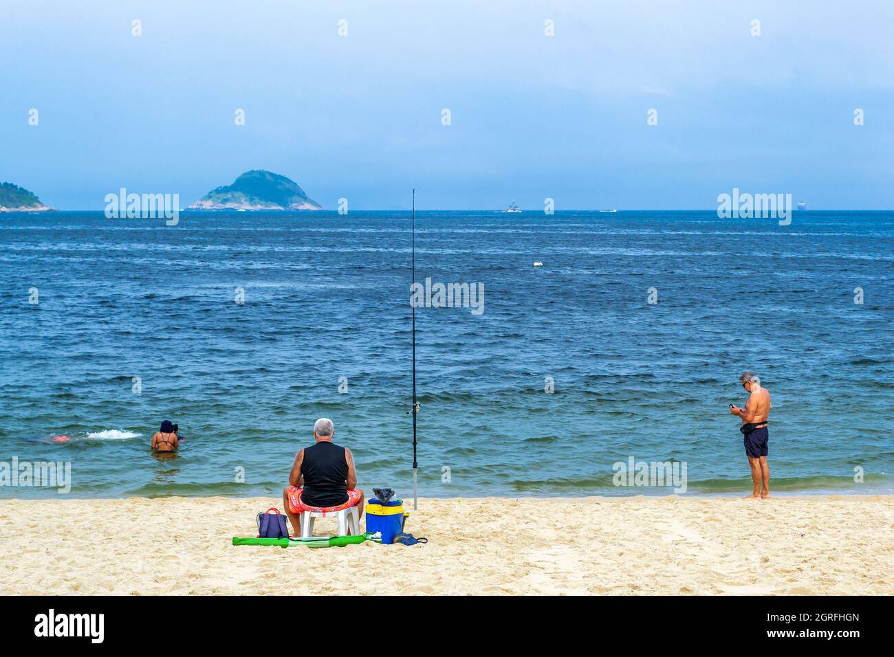 Brazilian man sitting in the sand by the Itaipu Lake in Rio de Janeiro ...