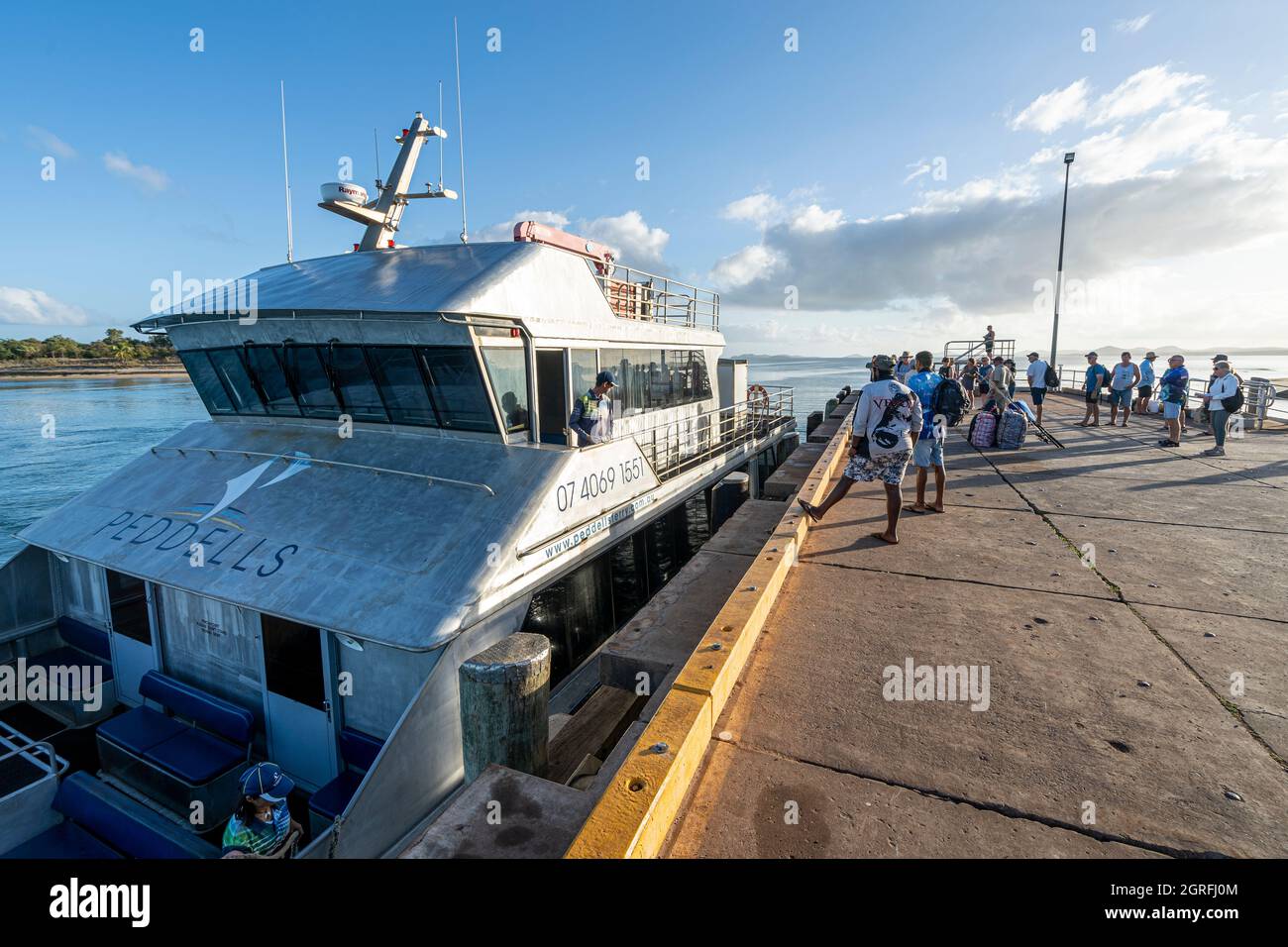 Torres Straits Ferry tied up with tourists waiting to board at Seisia ...