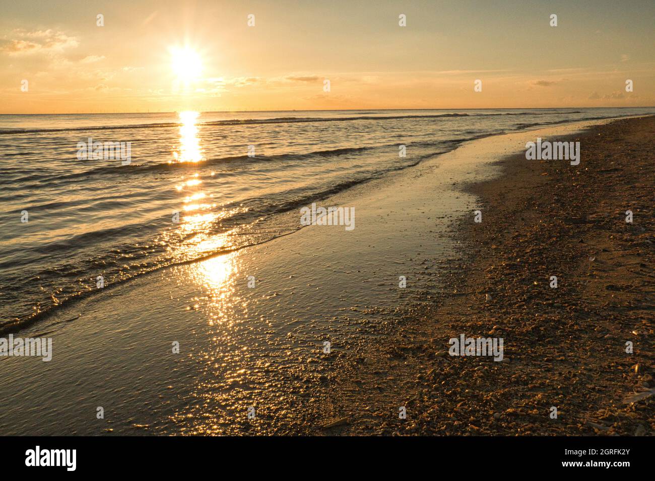 Sunset on the stand of Blåvand Denmark. Evening hours in warm light ...