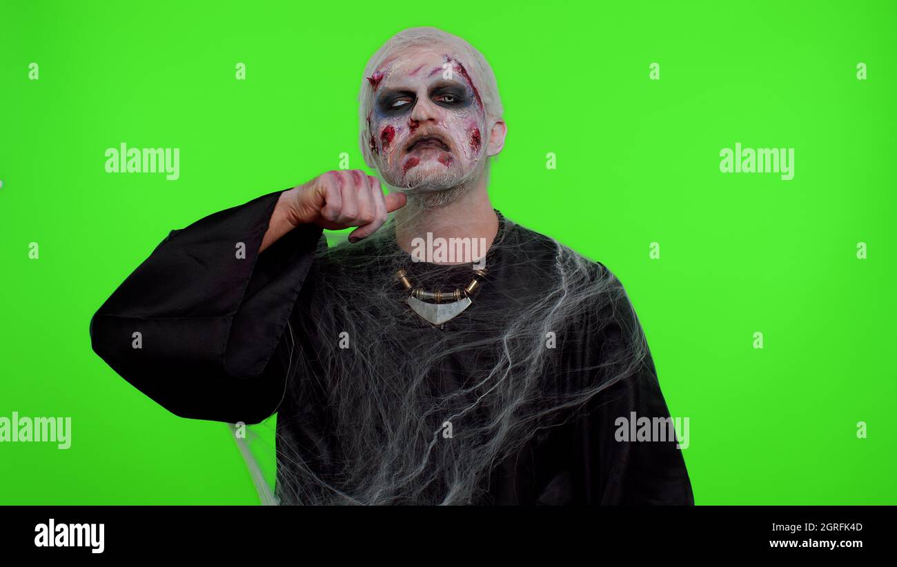 Sinister man Halloween zombie trying to scare showing killing gesture ...