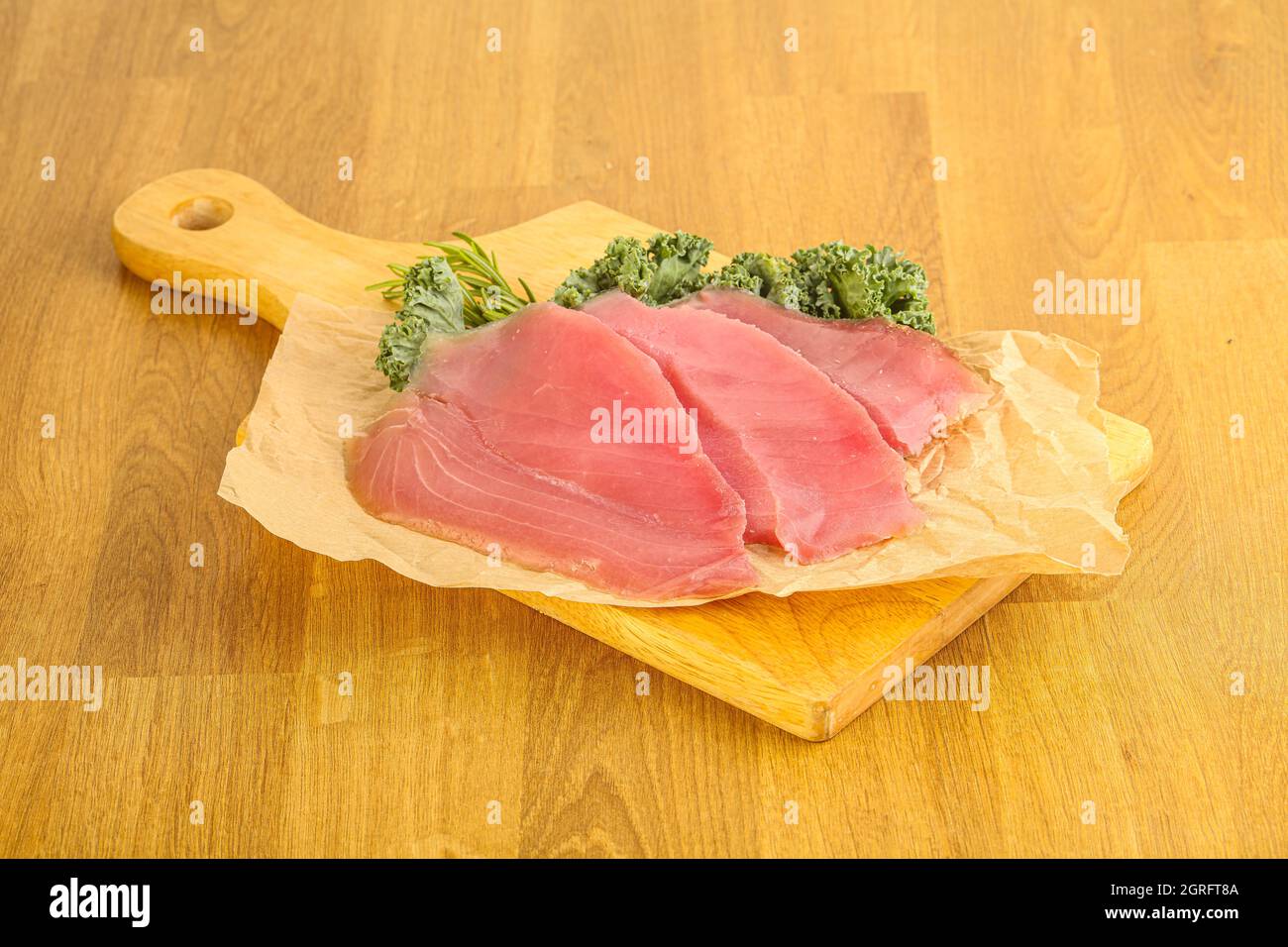 Raw salted tuna slice over board snack Stock Photo - Alamy