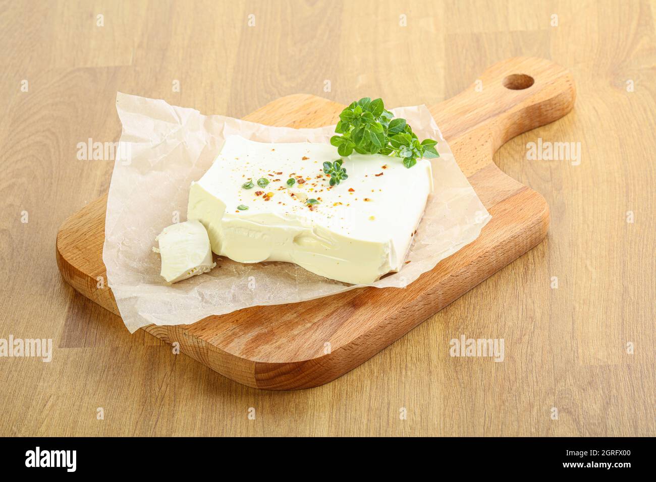 Greek Feta cheese over board served herbs Stock Photo - Alamy