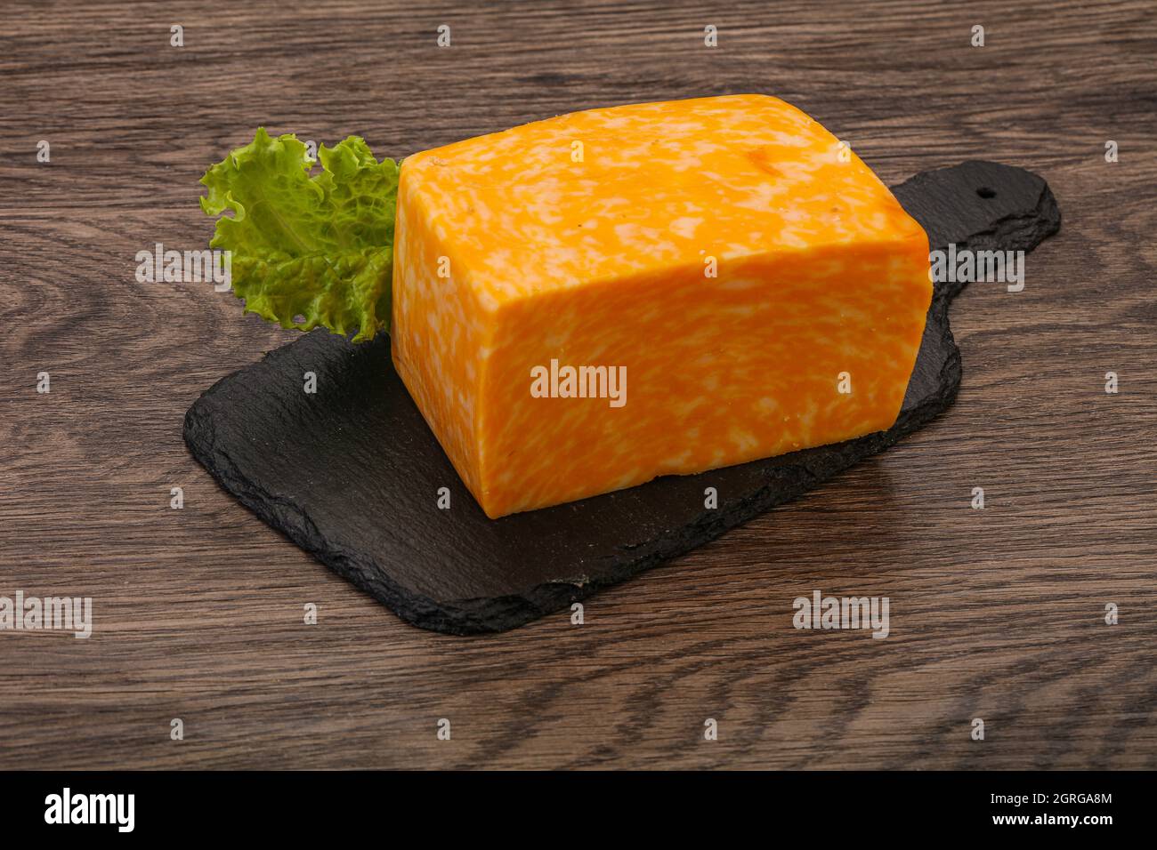 Dairy Marble cheese brick over board Stock Photo - Alamy