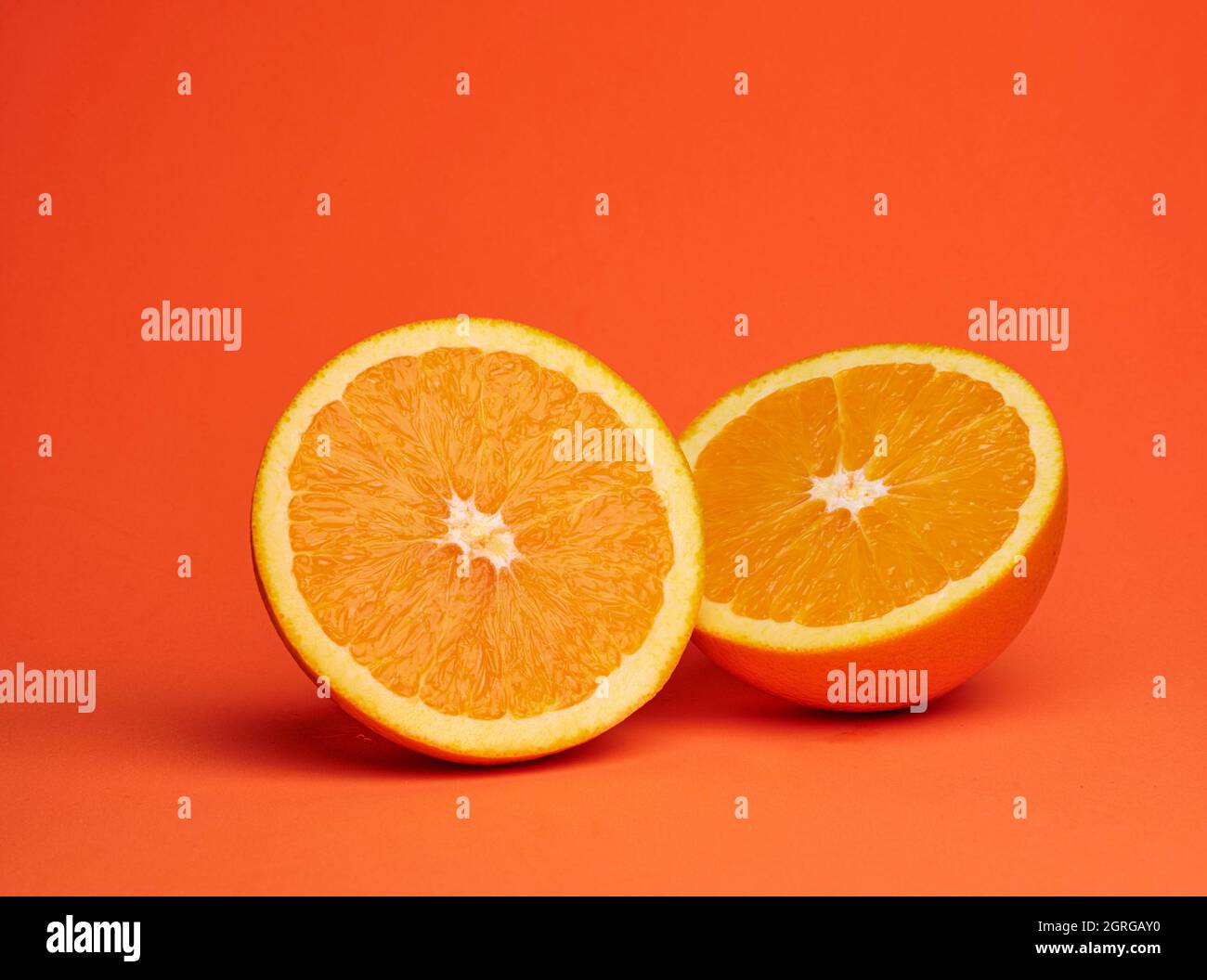sliced fresh orange on vibrant, monochromatic, orange background ...