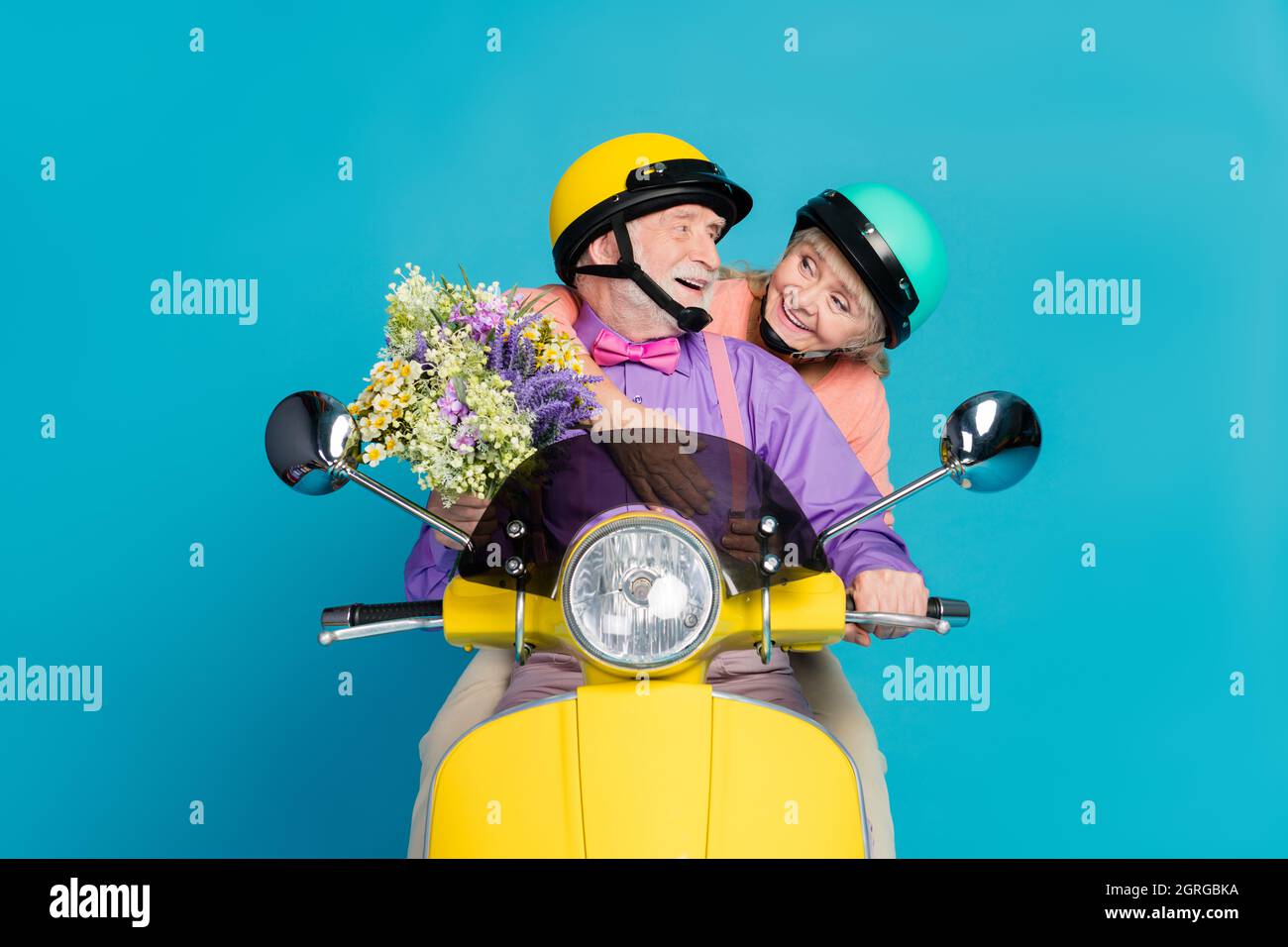 Portrait of attractive cheerful couple riding bike embracing pastime ...