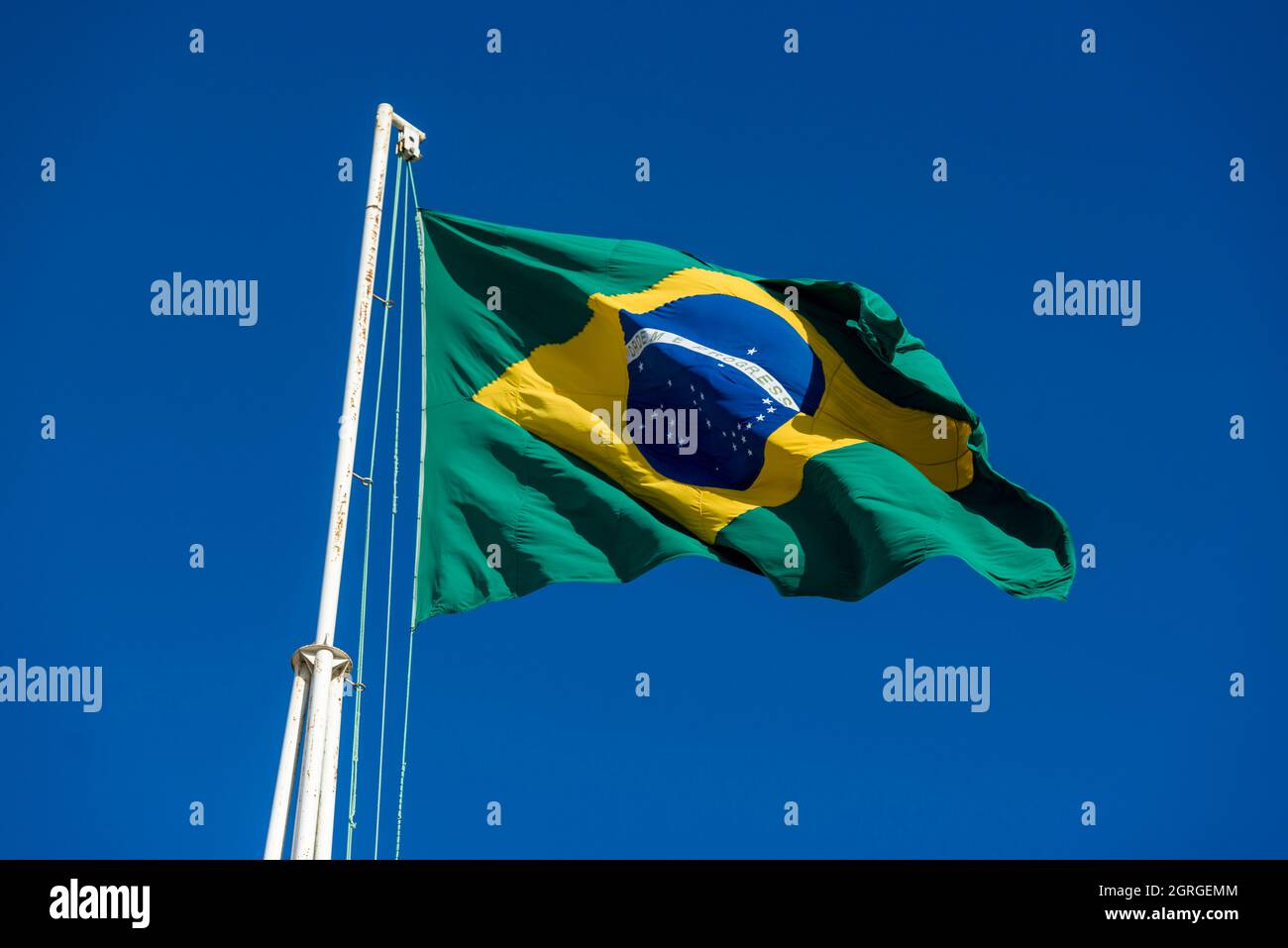 Brazilian flag hoisted with blue sky Stock Photo - Alamy