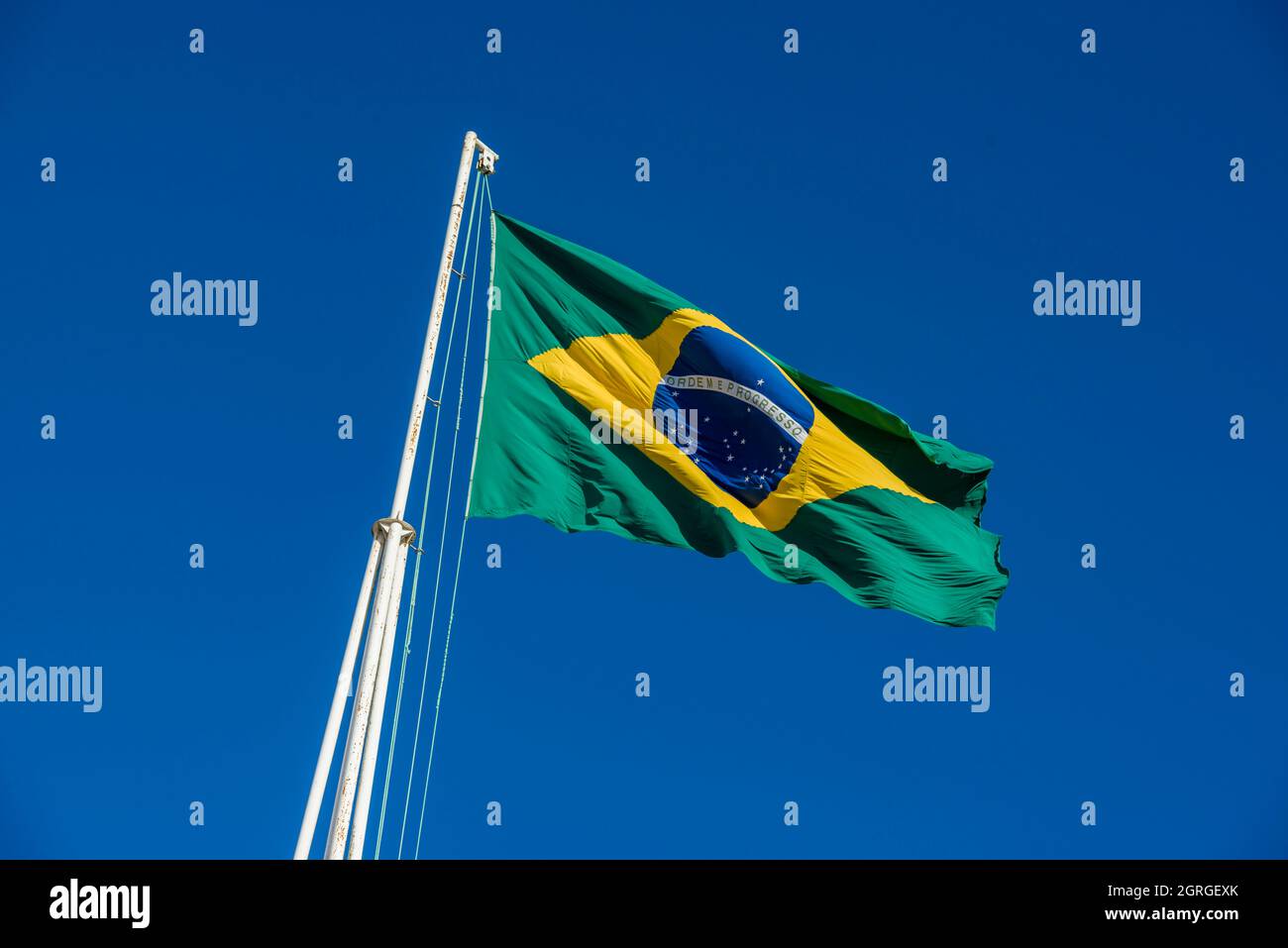 Brazilian flag hoisted with blue sky Stock Photo - Alamy