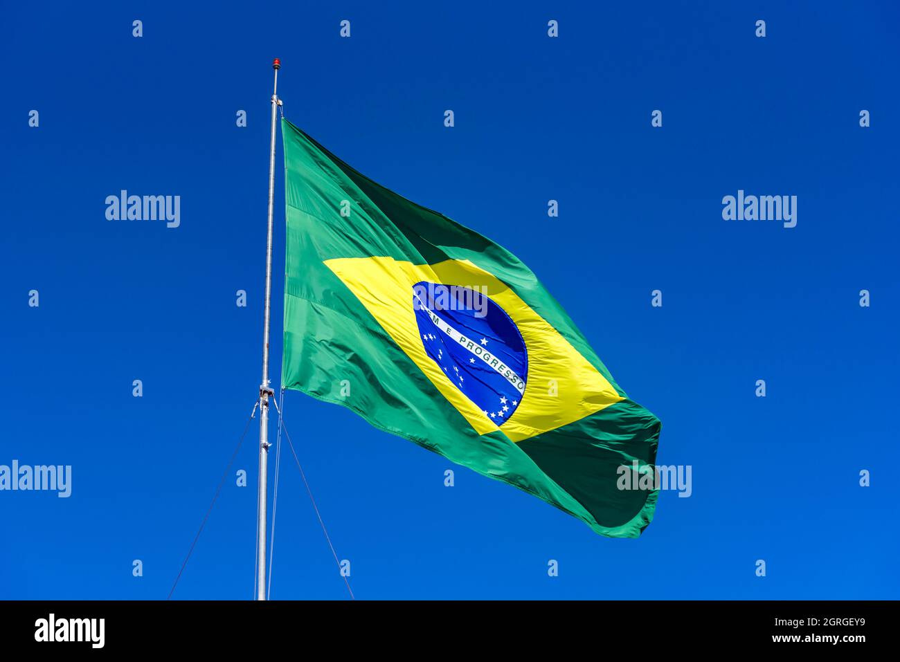 Brazilian flag hoisted with blue sky Stock Photo - Alamy