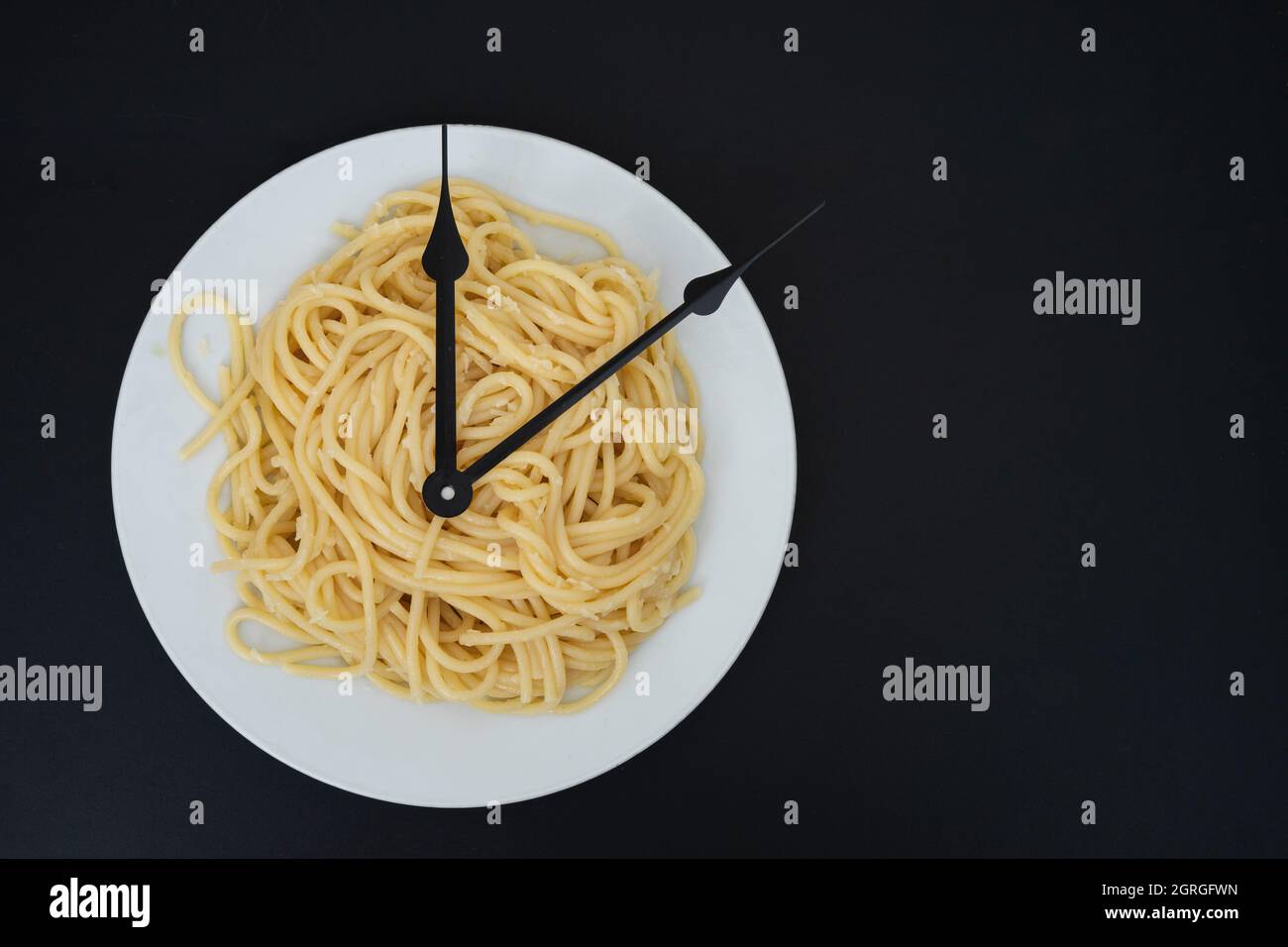 spaghetti on a white plate, on blue background, and clock tongues ...