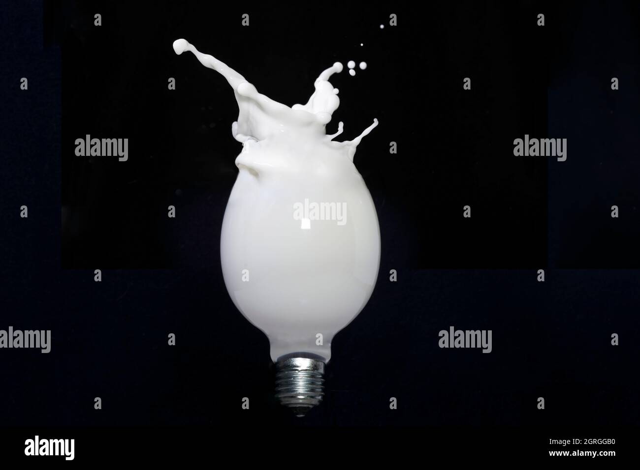 Milk splash in a light bulb, isolated on black Stock Photo - Alamy