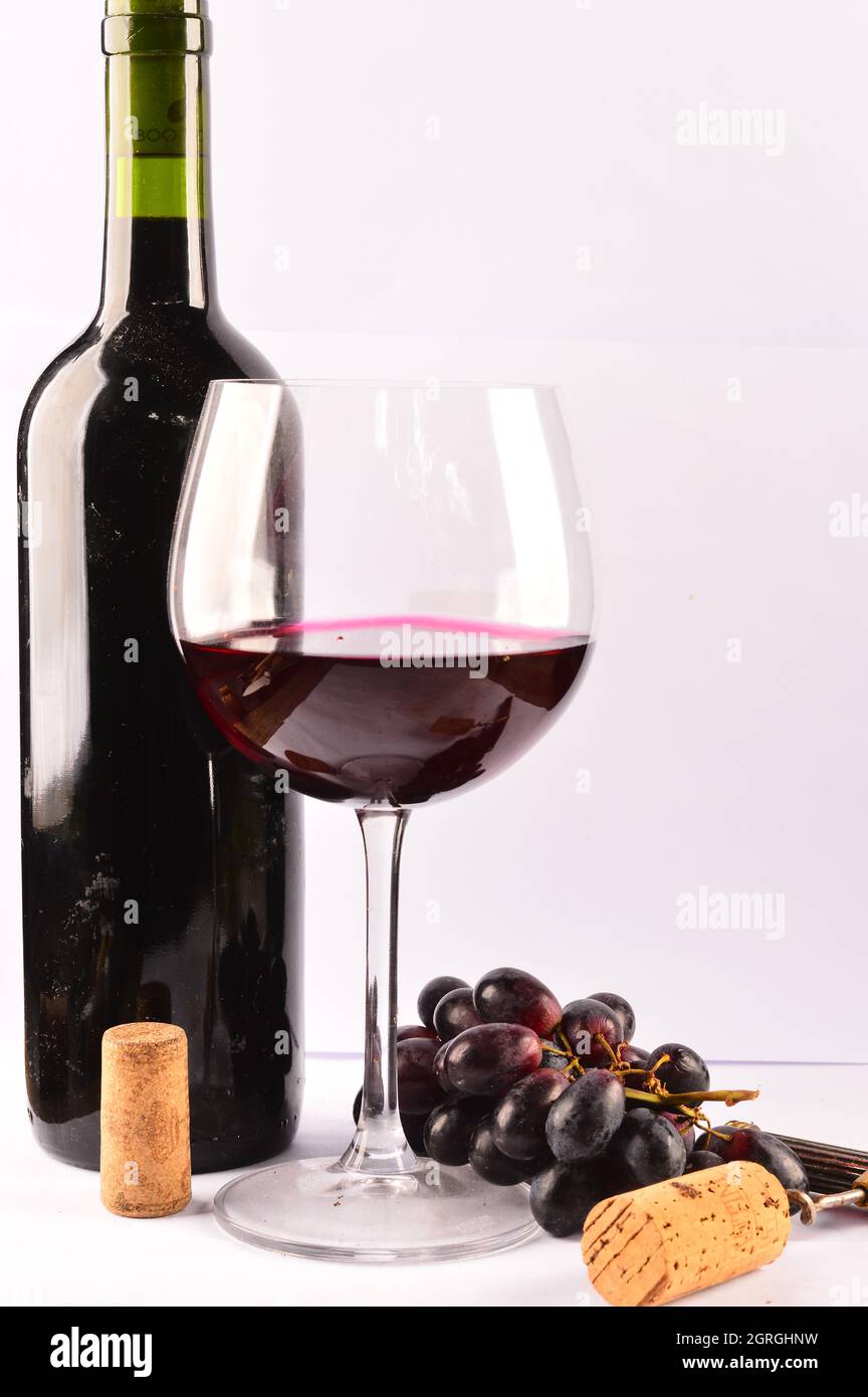 Glass and bottle of red wine and grapes on white background Stock Photo ...