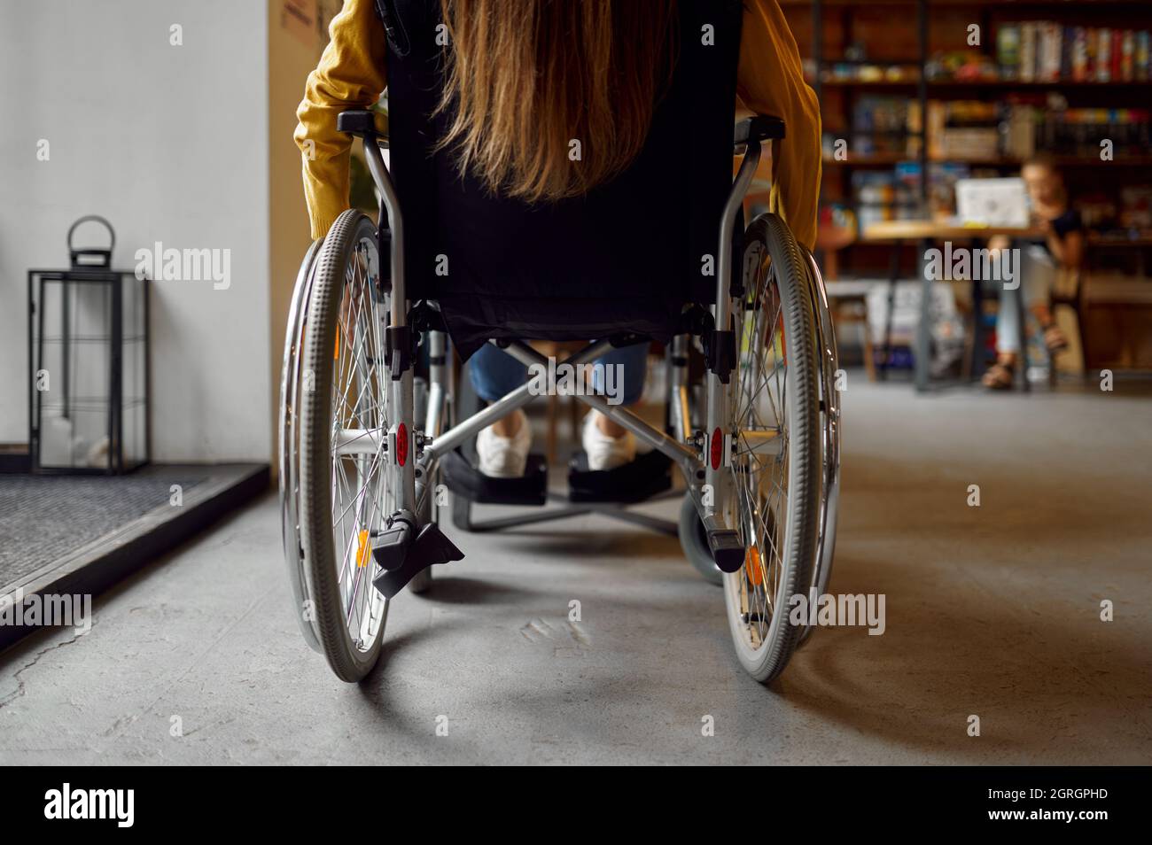 Disabled female student in wheelchair, back view Stock Photo - Alamy