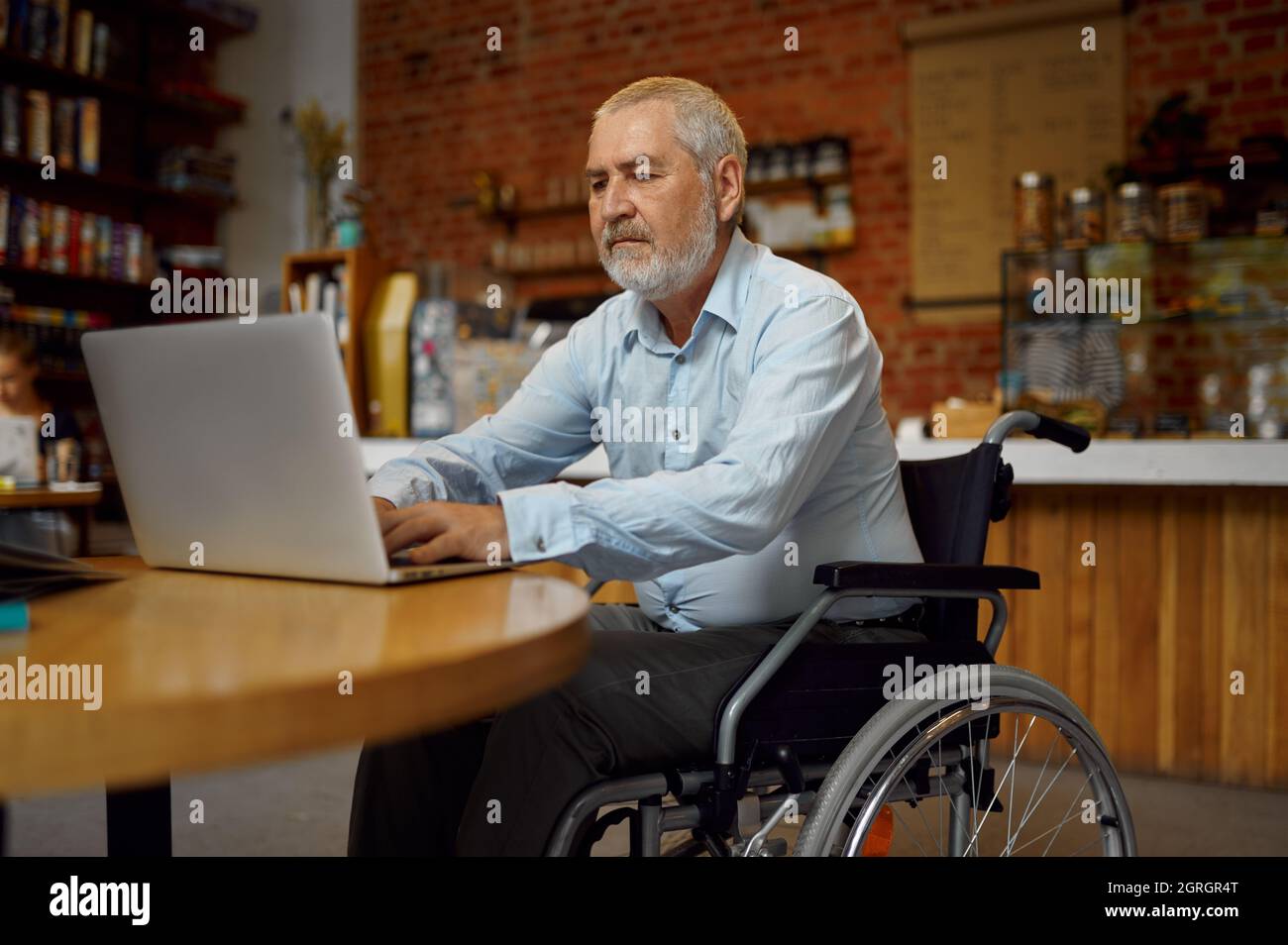 Adult disabled man in wheelchair using laptop Stock Photo - Alamy