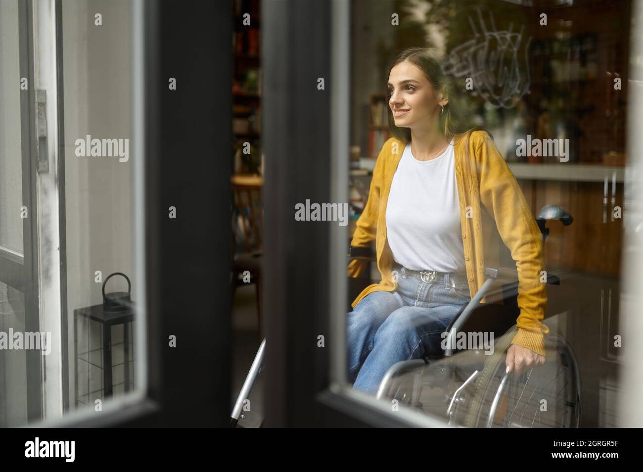 Disabled female student in wheelchair at window Stock Photo - Alamy