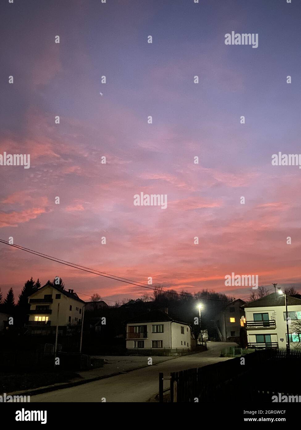 Vertical shot of town during twilight with a crimson sky Stock Photo ...
