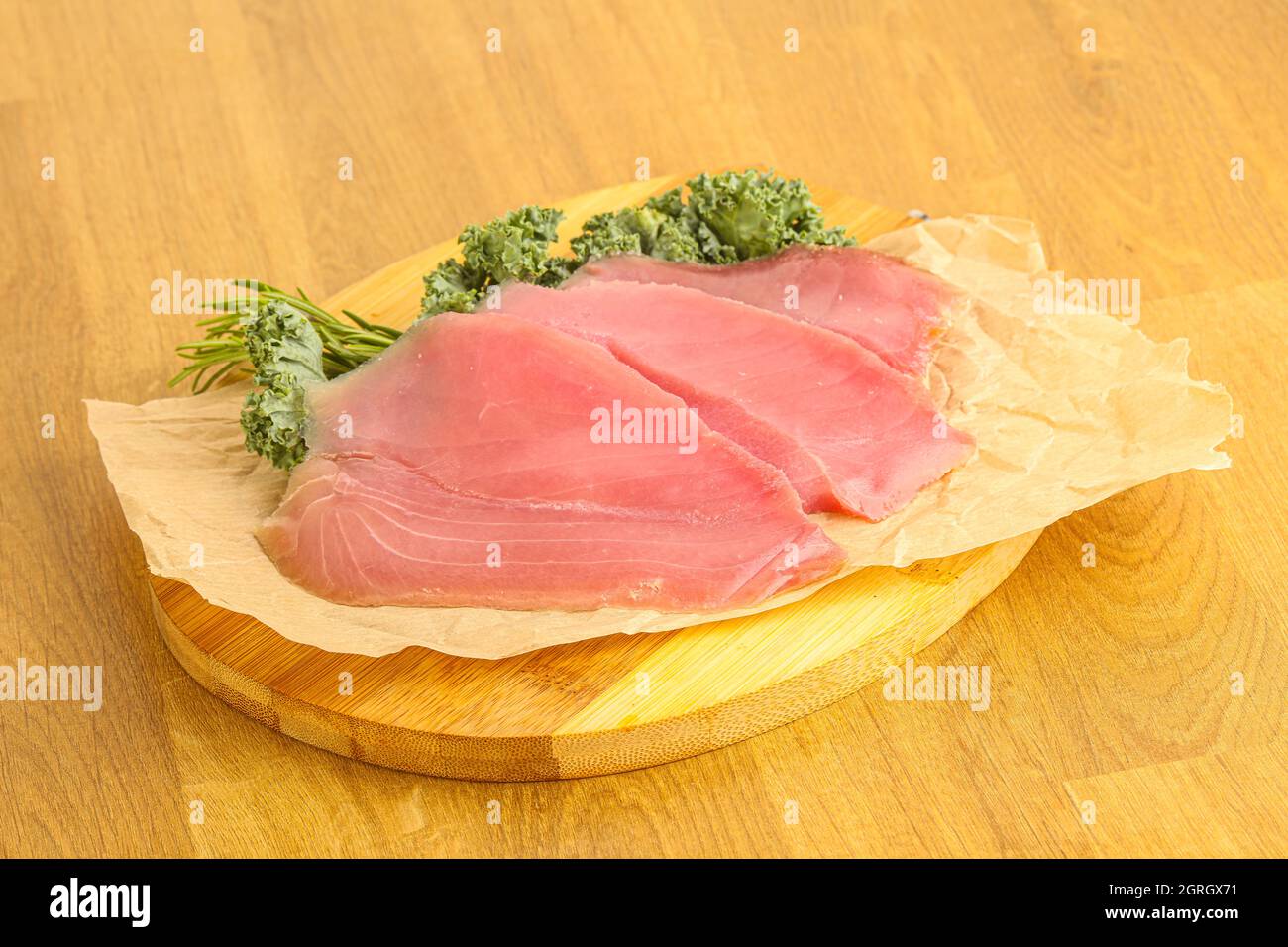 Raw salted tuna slice over board snack Stock Photo - Alamy