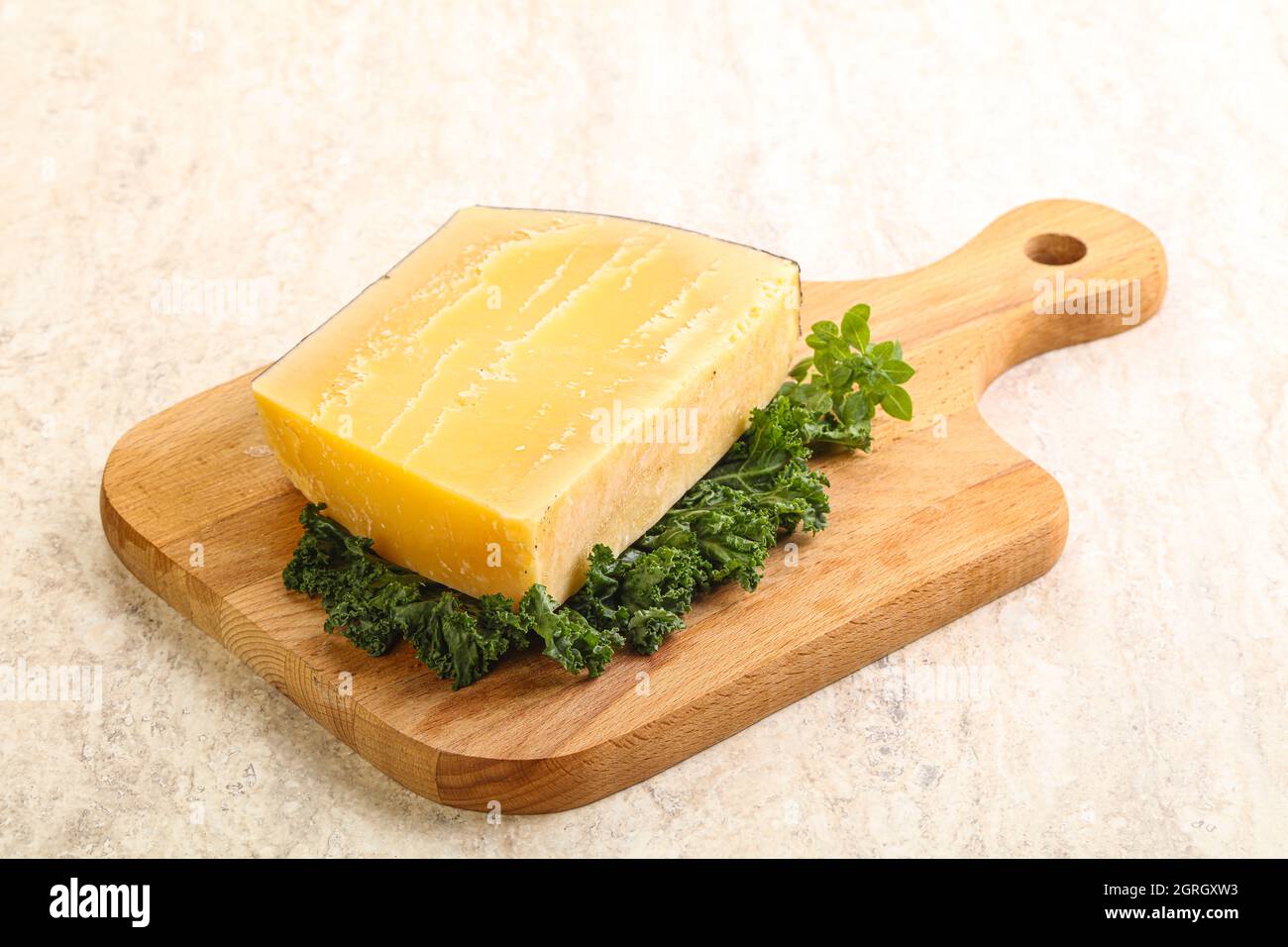 Hard Parmesan cheese piece over board Stock Photo - Alamy