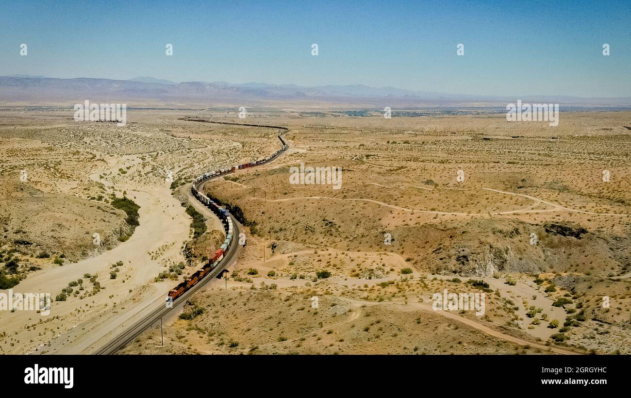 Freight train hauling cargo through a desert landscape Stock Photo - Alamy