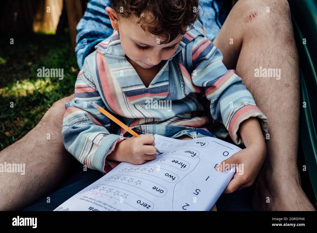 Loving moment of father helping young son with homework Stock Photo - Alamy