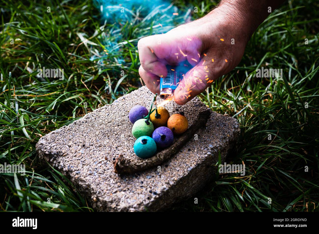 Male hand lighting fireworks with lighter Stock Photo - Alamy