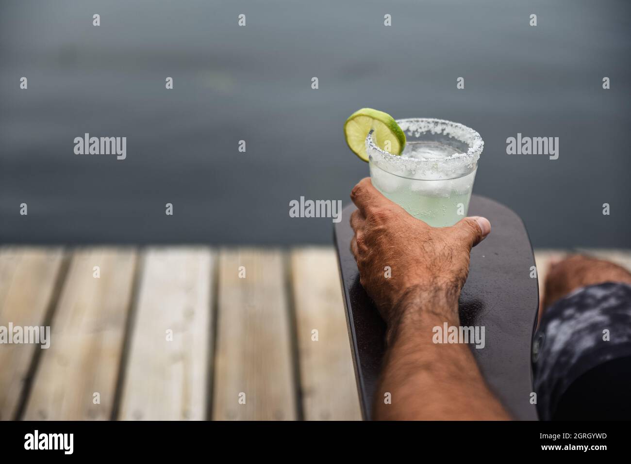 Close up of hand holding a margarita cocktail on a dock Stock Photo - Alamy