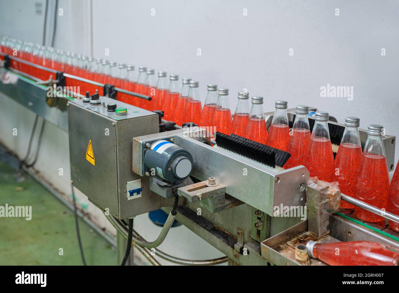 Glass bottled red juice on steel conveyor of production line in ...
