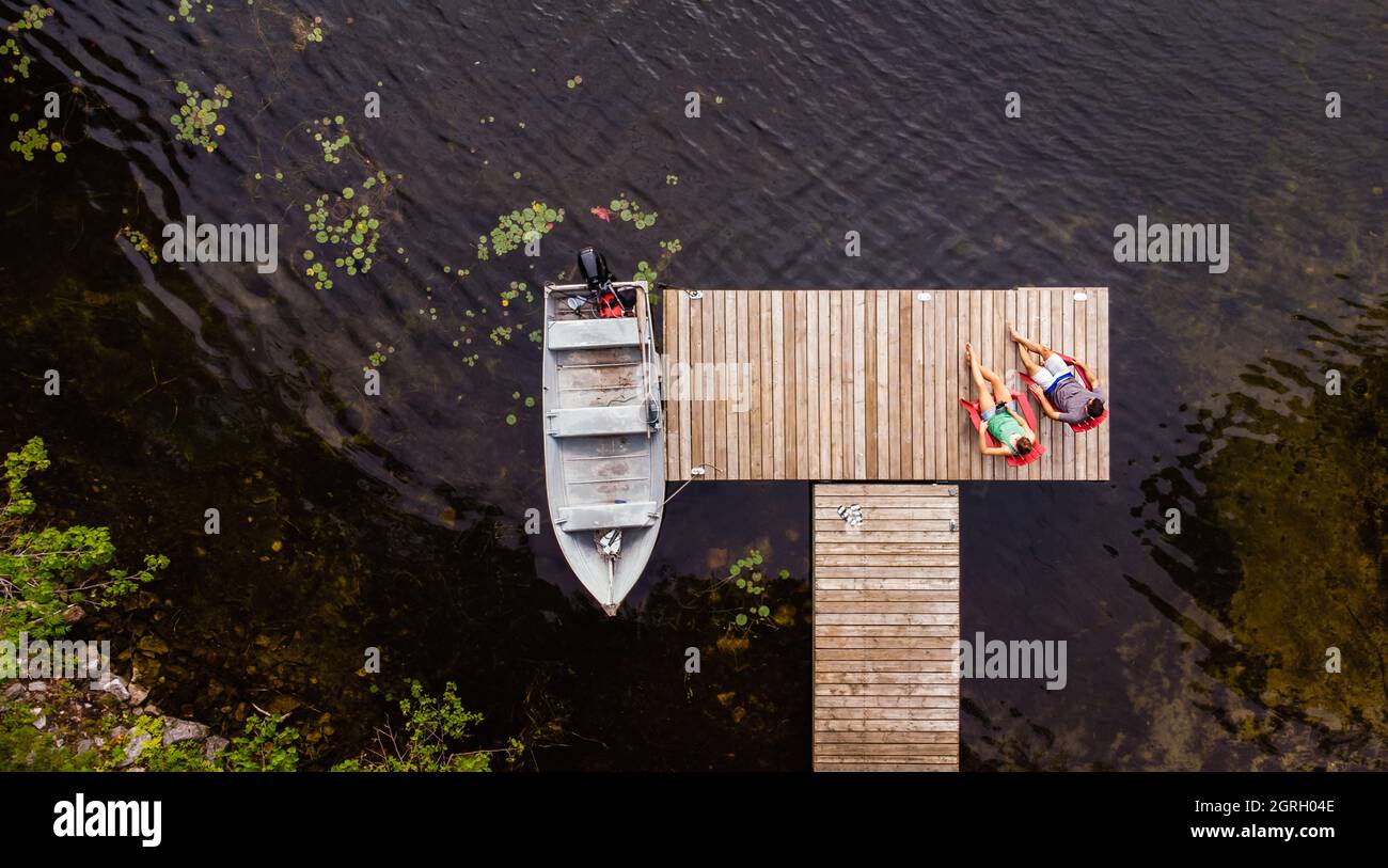 Overhead aerial image of couple sitting on a dock together Stock Photo ...