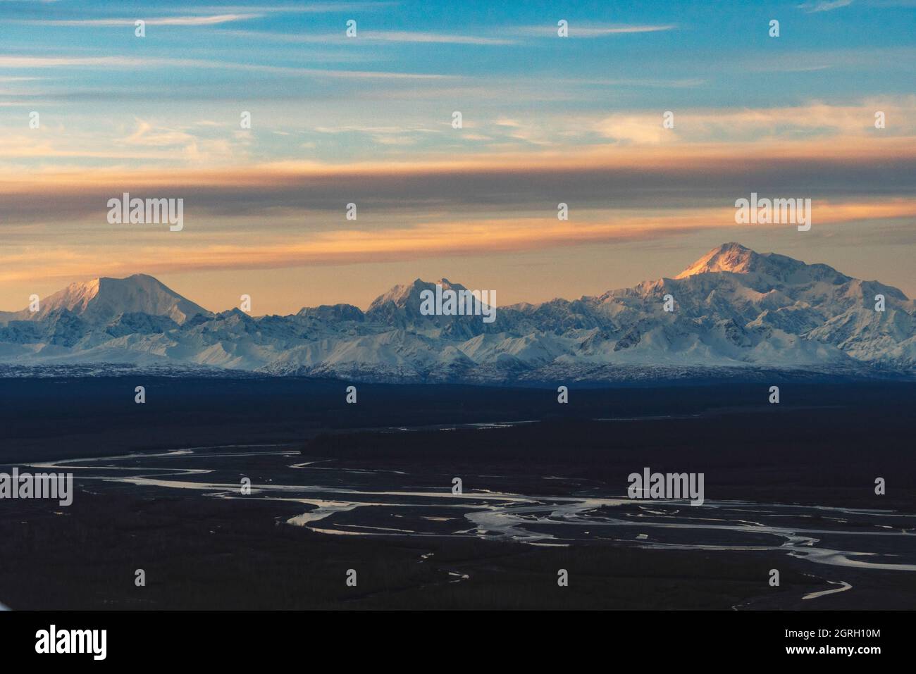 Sunset light shines on the big three high peaks of the Alaska Range ...