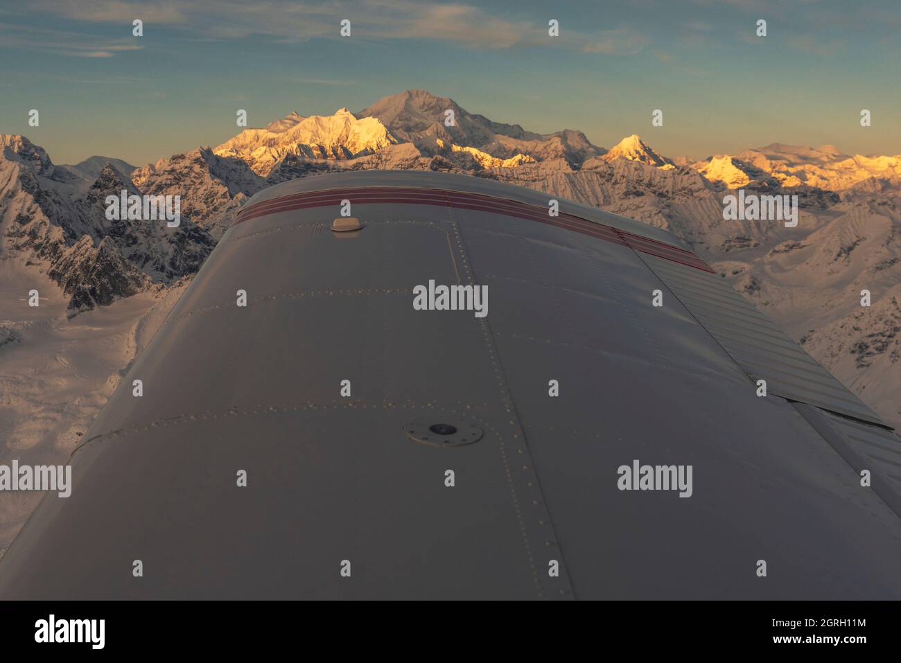 Aerial view at sunset of Denali and Alaska Range with airplane wing of ...