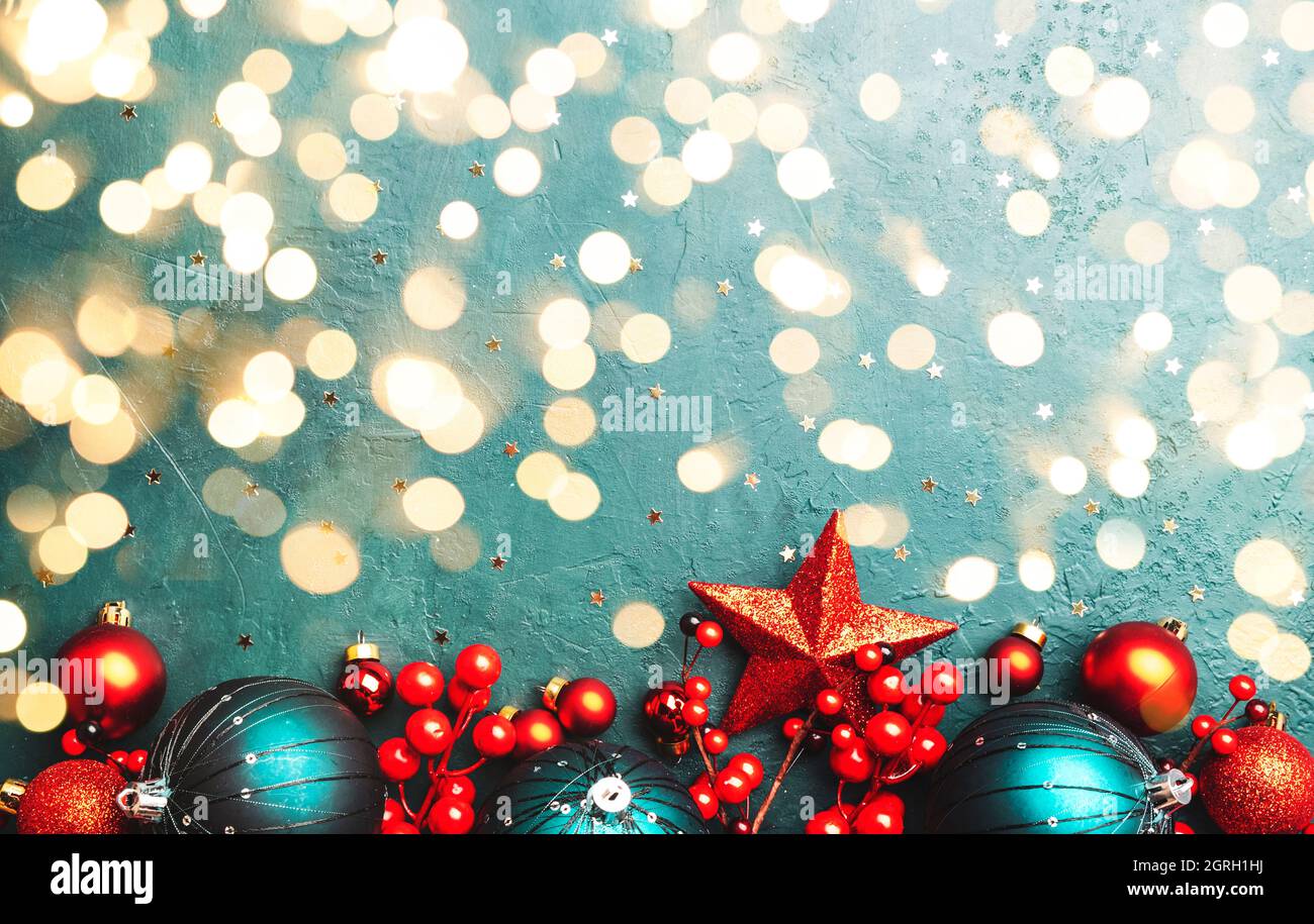 Blue Christmas or New Year background with red and blue Christmas balls, berries, garland lights ...