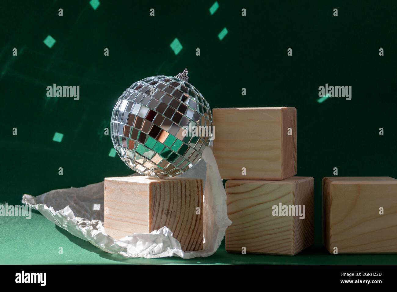 Still life with wooden cubes and disco ball reflecting sun flares ...