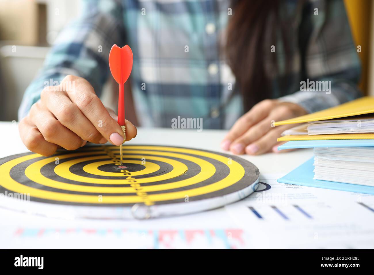 Businesswoman puts dart in center of darts at workplace in office Stock ...