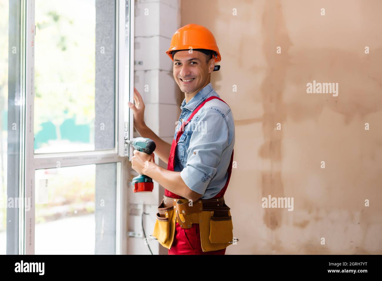 Man worker mounting window in a renovated building Stock Photo - Alamy